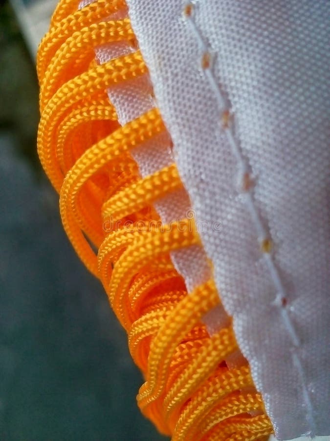 The Surface Edge of the White Flag Fabric with Golden Yellow Tassel ...