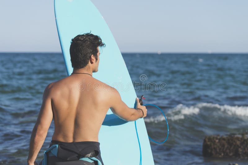 Surfer Carrying His Blue Surfboard from Behind Stock Image - Image of ...