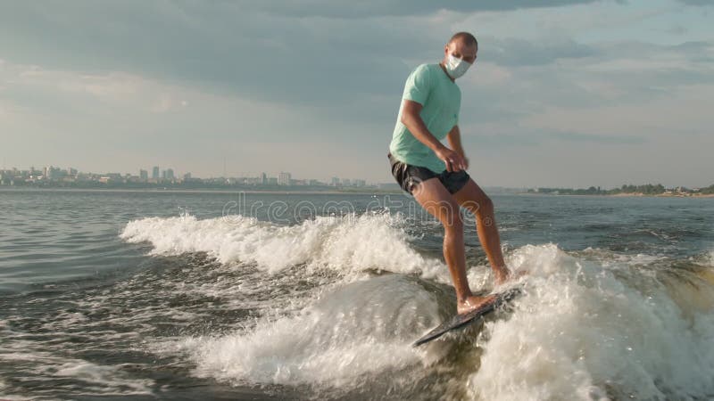 A Surfer Jumping on a Wakeboard in a Mask. an Experienced Wakeboarder ...