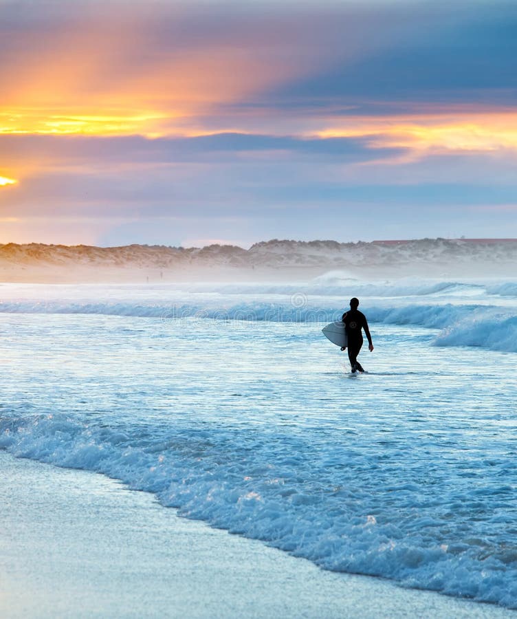 Surfer at sunset stock photo. Image of strolling, silhouette - 65986780