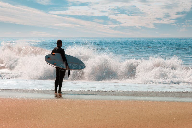Surfer with Surfboard Looks into the Distance at the Ocean Stock Image ...