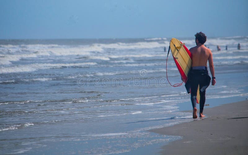 Surfer walking down beach editorial photography. Image of male - 100421412