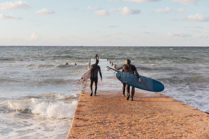Surfers on Boards Riding the Waves in a Storm at Sea Stock Photo ...