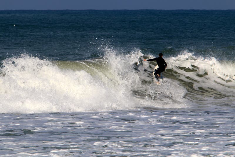 Surfing - riding the waves editorial image. Image of wave - 135032565