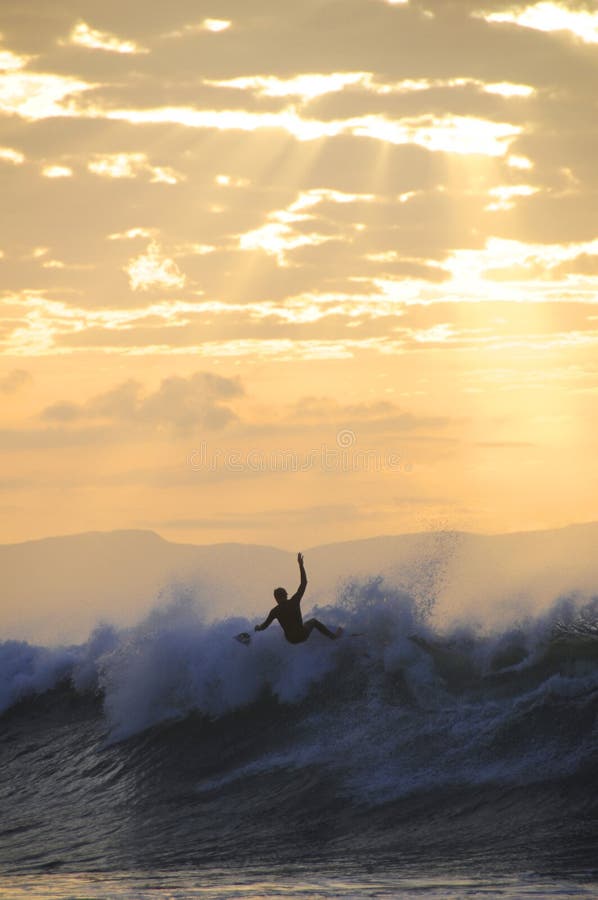 A Surfer Riding a Big Wave at Sunset Stock Photo - Image of recreate ...