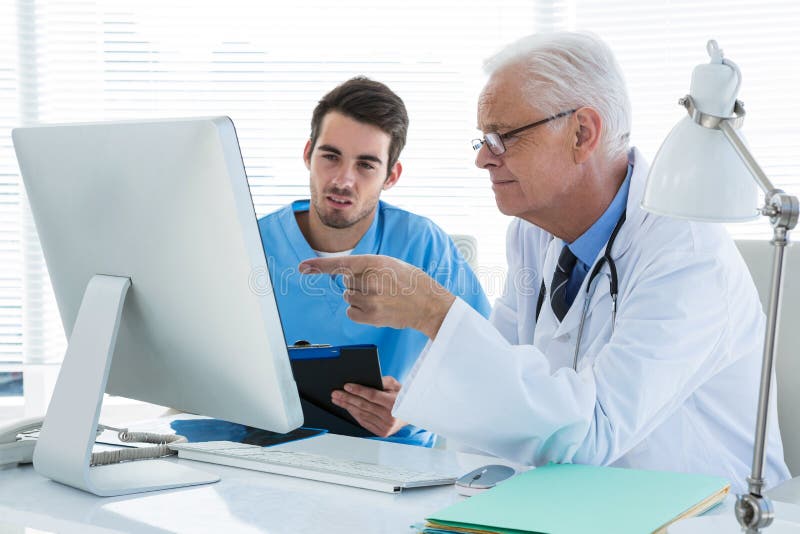 Surgeon and Doctor Discussing Over Personal Computer Stock Image ...