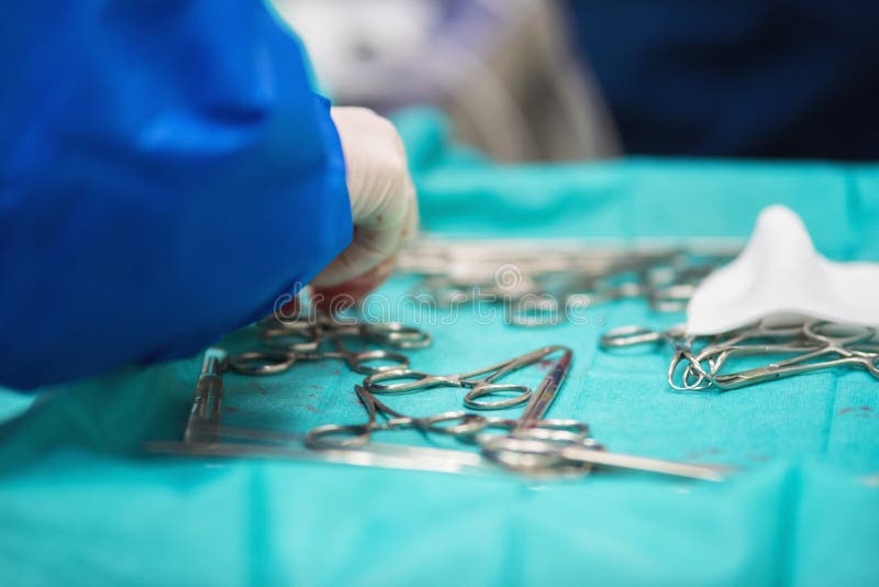 Surgeon Hand Picking Up an Instrument from Tray of Surgical Instruments ...