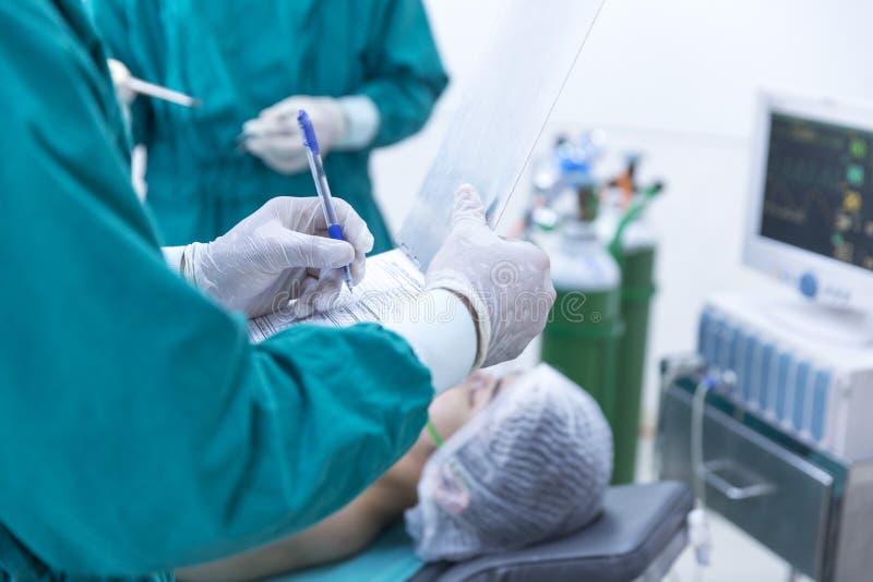 The Surgeon in the Operating Room is Writing Down the Illness in the ...