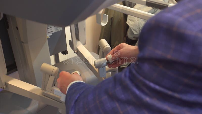 A Surgeon in a Plaid Jacket Tests the Control Knobs of a New Medical ...