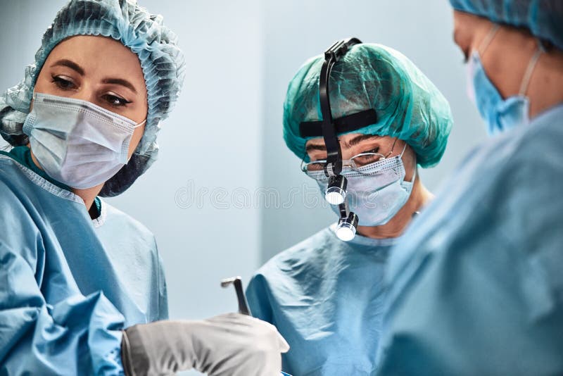 A Surgeon S Team in Uniform Performs an Operation on a Patient in the ...