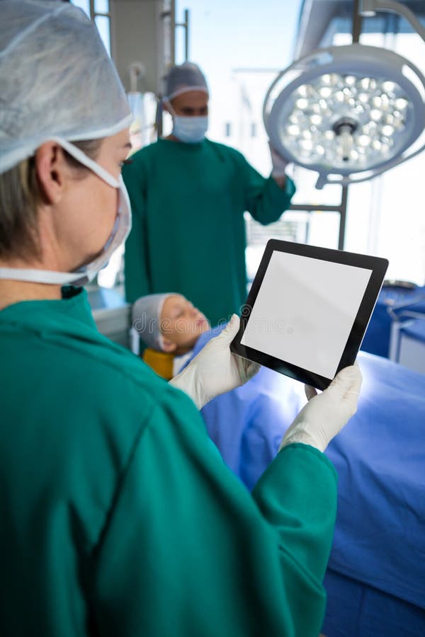 Surgeon Using Digital Tablet while Operating Patient Stock Image ...