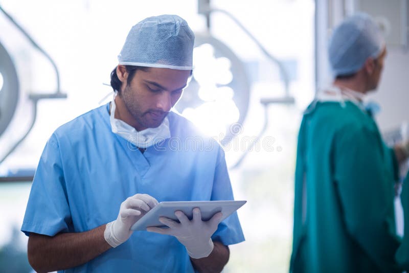 Surgeon Using Digital Tablet in Operation Room Stock Photo - Image of ...