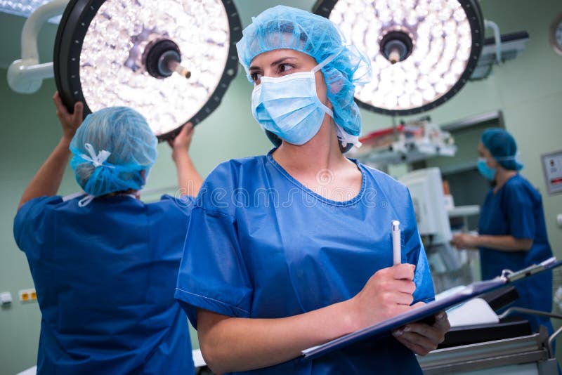 Surgeon Writing on Clipboard in Operation Room Stock Image - Image of ...
