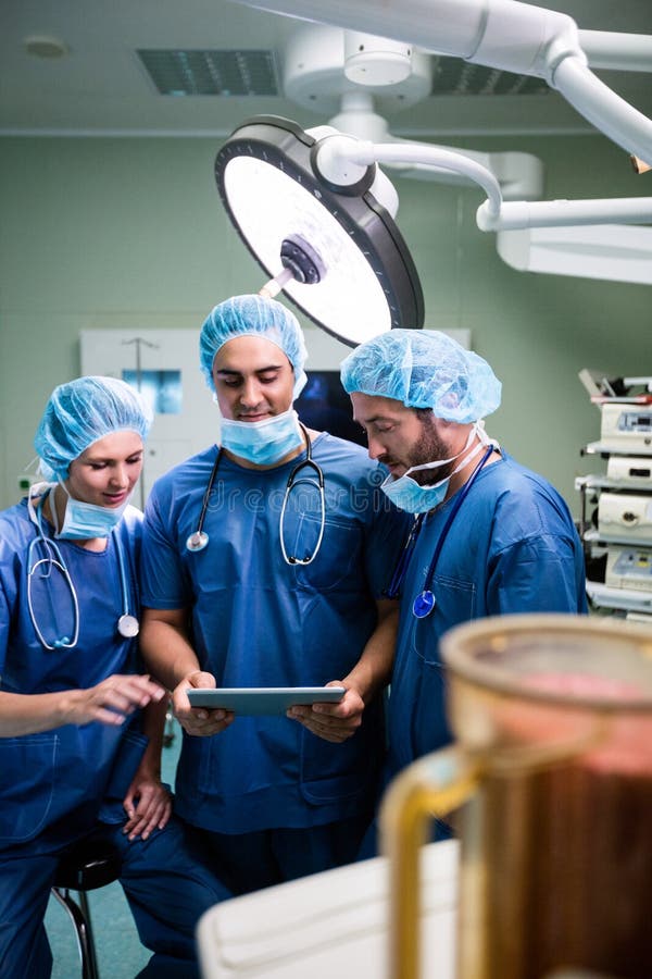 Surgeons Discussing Over Digital Tablet in Operation Room Stock Photo ...