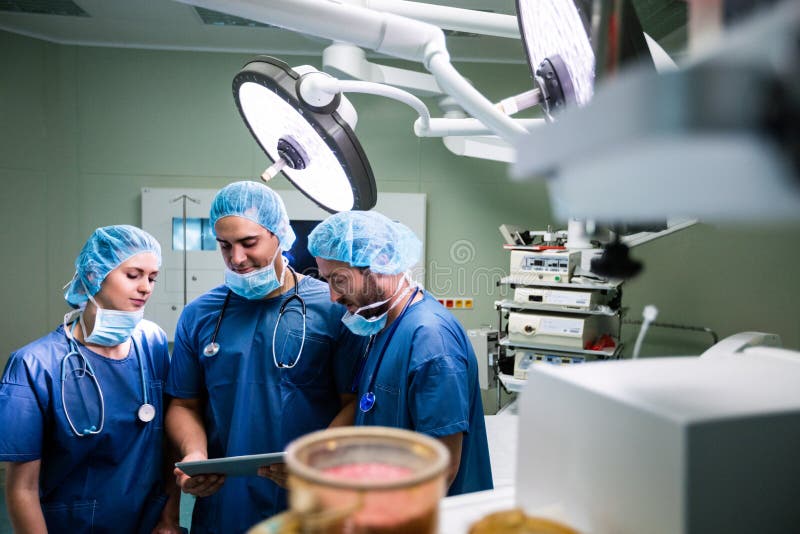 Surgeons Discussing Over Digital Tablet in Operation Room Stock Photo ...