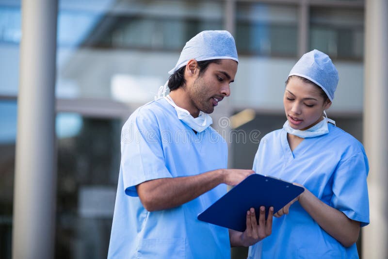 Surgeons Discussing Over Medical Reports Stock Photo - Image of focused ...