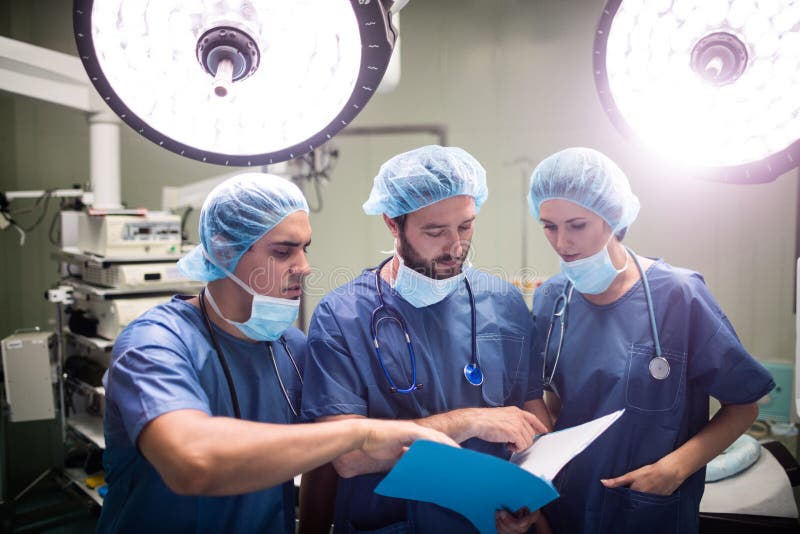Surgeons Discussing Patient Records in Operation Room Stock Image ...