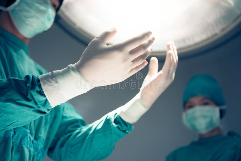Midsection View of Hands in Surgical Gloves and Surgical Lights in the ...