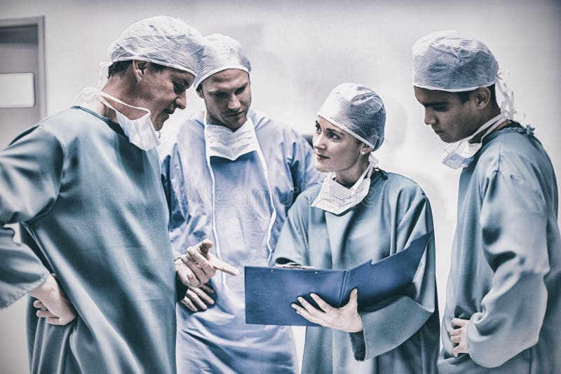Surgeons Having Discussion on File in Corridor Stock Photo - Image of ...