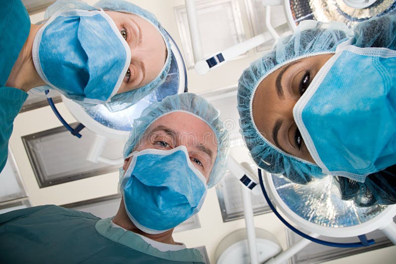 Two Surgeons Looking Down, Working, and Holding Surgical Equipment with ...
