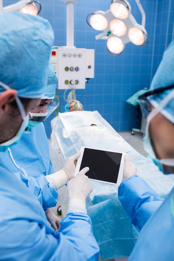 Surgeons Using Digital Tablet and Patient Lying on Operation Bed Stock ...