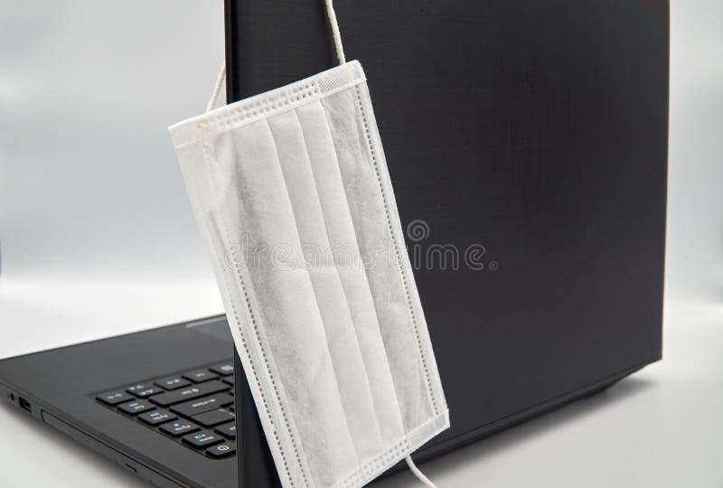 Surgical Face Mask Hanging on Top of Laptop Stock Photo - Image of ...
