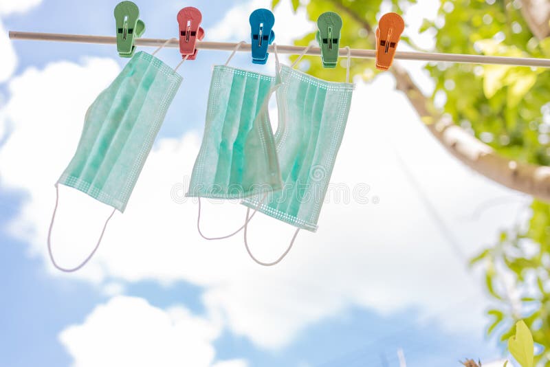 Surgical Face Masks Drying in Sun on a Rope with Blue Sky in Background ...
