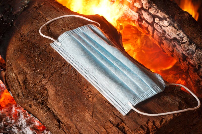 Surgical Mask Burning on Top of a Log with Fire, Concept of Ending ...