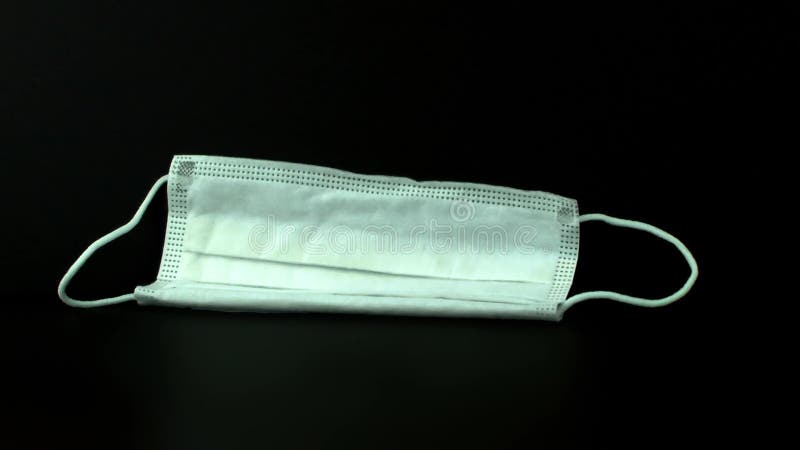Surgical Masks, Face Mask Disposable Falling on a Black Surface Stock ...