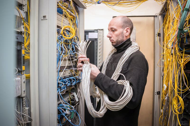 The Technician, All Wrapped in Cables, Connects the Wires in the Rack ...