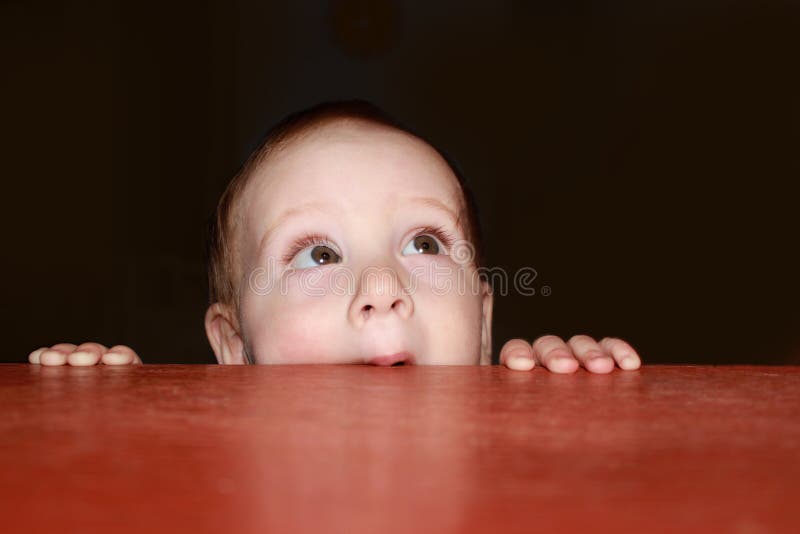 Surprised Little Boy Peeking from a Table Stock Photo - Image of ...