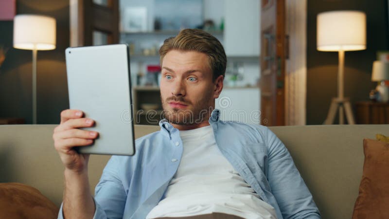 Wondering Man Surprised Face Reading Tablet Closeup. Guy Watching Tab ...