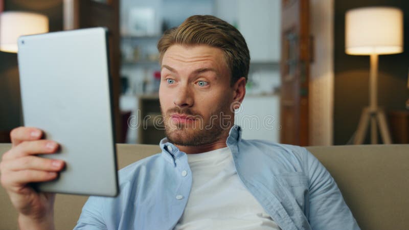 Surprised Man Reading Tablet Screen at House Closeup. Wondering Guy ...