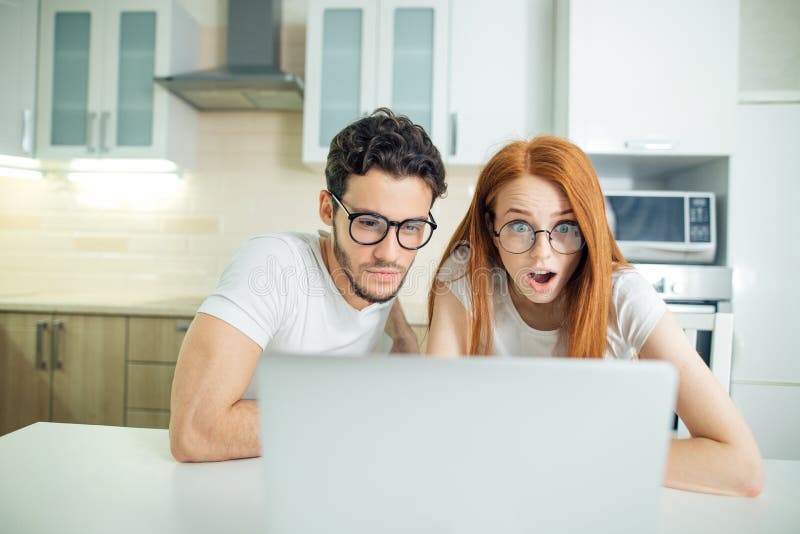 Shocked Couple Watching Something on Laptop at Home Stock Image - Image ...