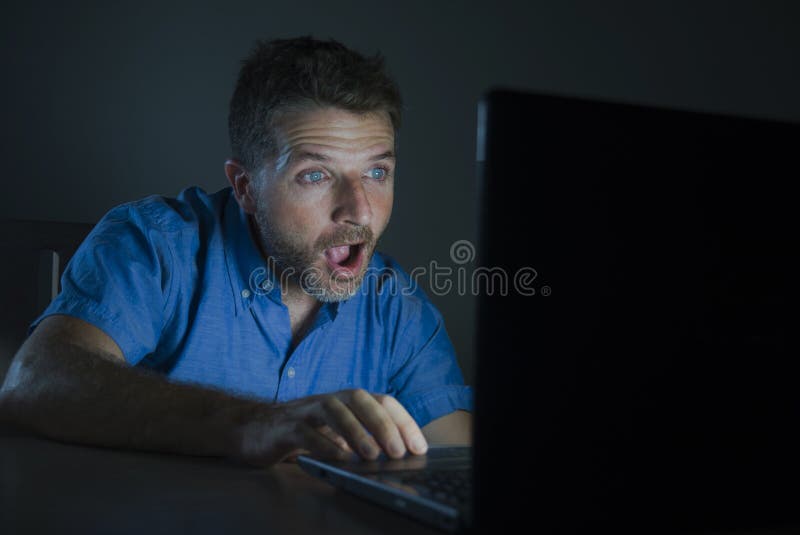 Surprised and Shocked Man at Night Working with Laptop Computer in the ...