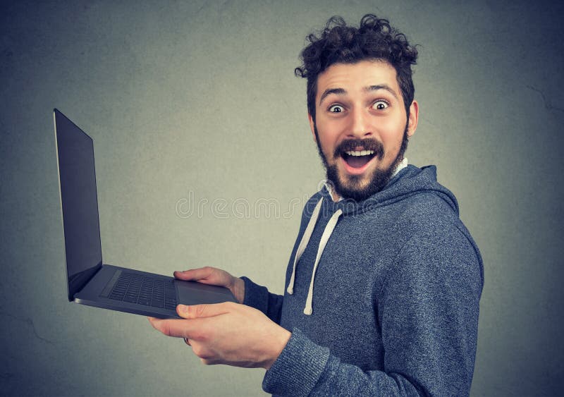 Surprised Young Man with Laptop Computer Looking at Camera Stock Photo ...