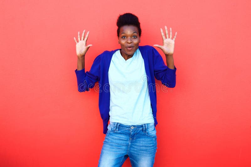 Surprised Young Woman Standing With Her Hands Raised Stock Image