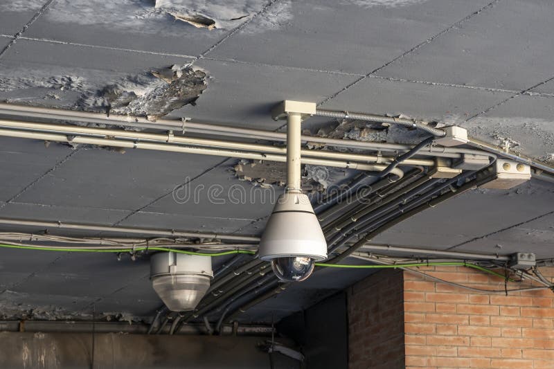 Surveillance Camera Hanging from the Ceiling in an Area with Peeling ...
