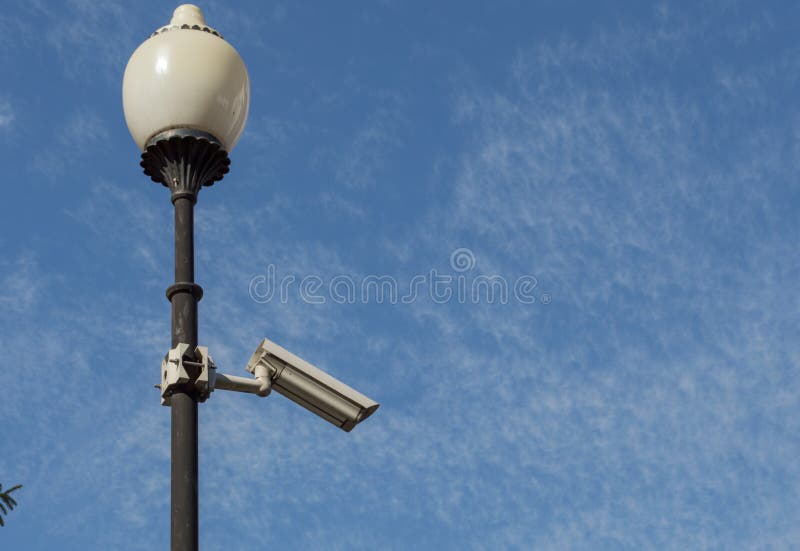 Surveillance Camera on a Pole with a Lantern, Against Blue Sky Stock ...