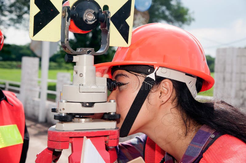 Surveyor or Engineer Setting Prism Reflector with Partner on the Field ...