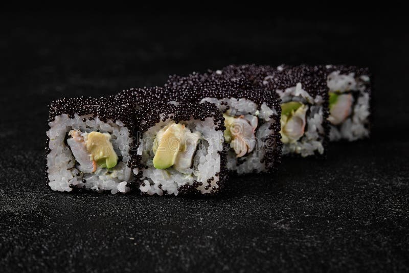 Sushi Roll with Shrimp Inside and Black Flying Fish Roe on Top on Black ...
