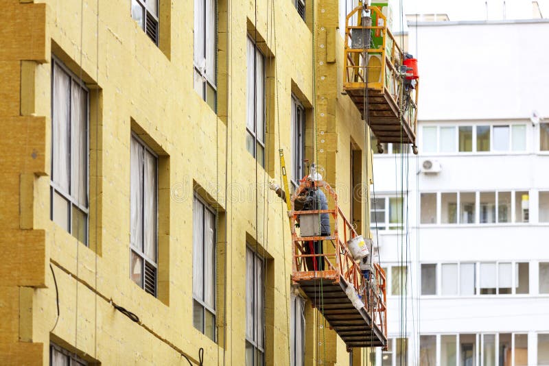 Construction Cradle with Two Workers. Process of the Wall Insulation ...