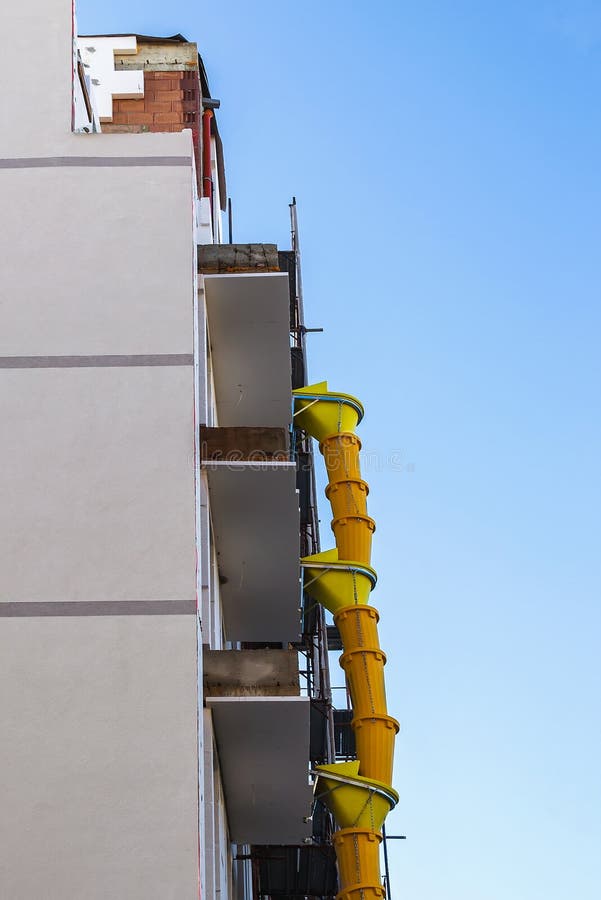 Suspended Sections of Yellow Garbage Chute on a Facade of Building ...