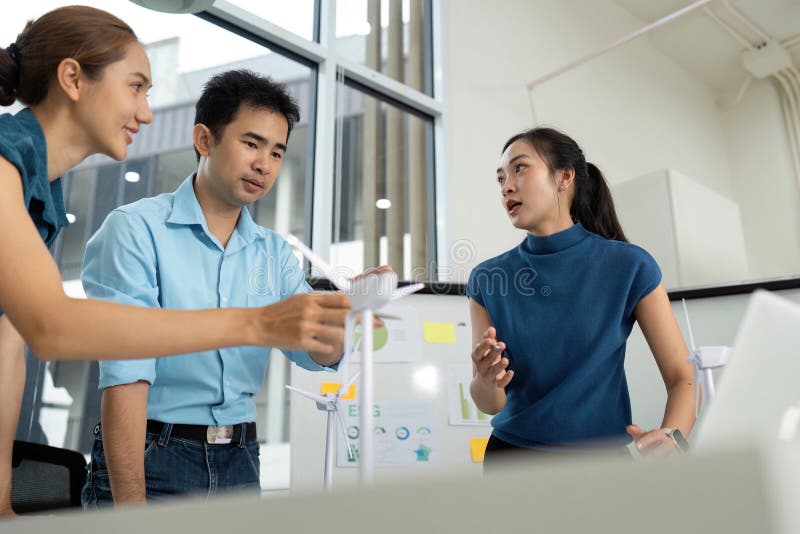Sustainability Focus. Team Members Analyzing Wind Energy Models in a Creative Workspace. Stock ...