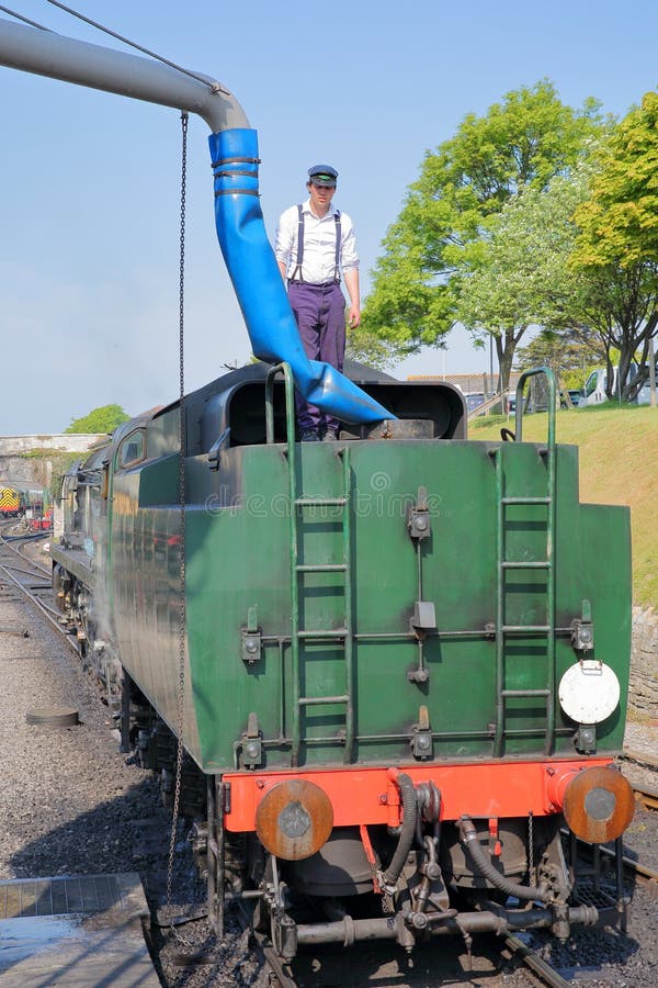 An Engineer Working at the Top of a Steam Train at Swanage Railway ...