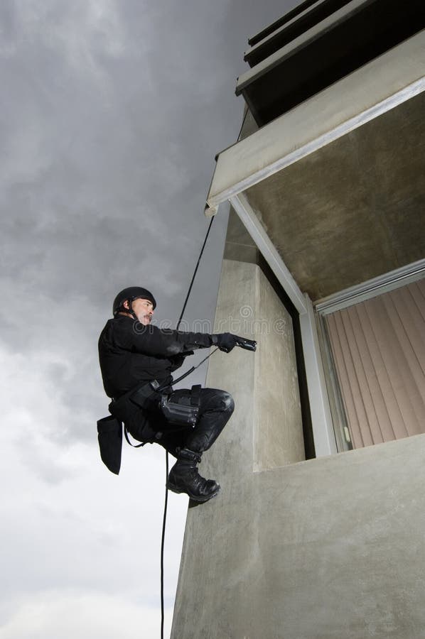 SWAT Team Officer Aiming Gun while Rappelling Stock Photo - Image of ...