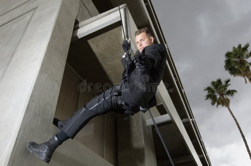 SWAT Team Officer Rappelling and Aiming Gun Stock Image - Image of ...