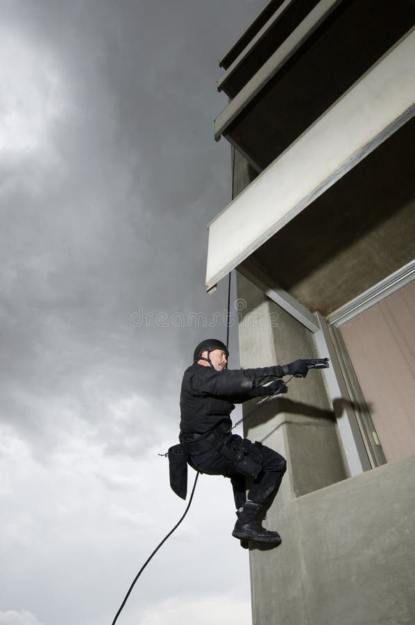 SWAT Team Officer Aiming Gun while Rappelling Stock Photo - Image of ...