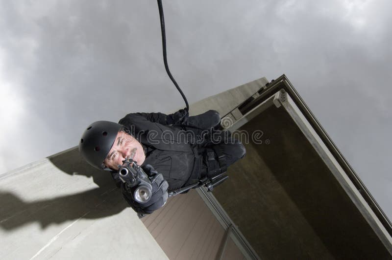 SWAT Team Officer Rappelling and Aiming Gun Stock Photo - Image of ...