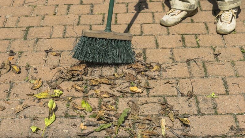 Sweeping leaves a broom stock photo. Image of bricks - 75358010